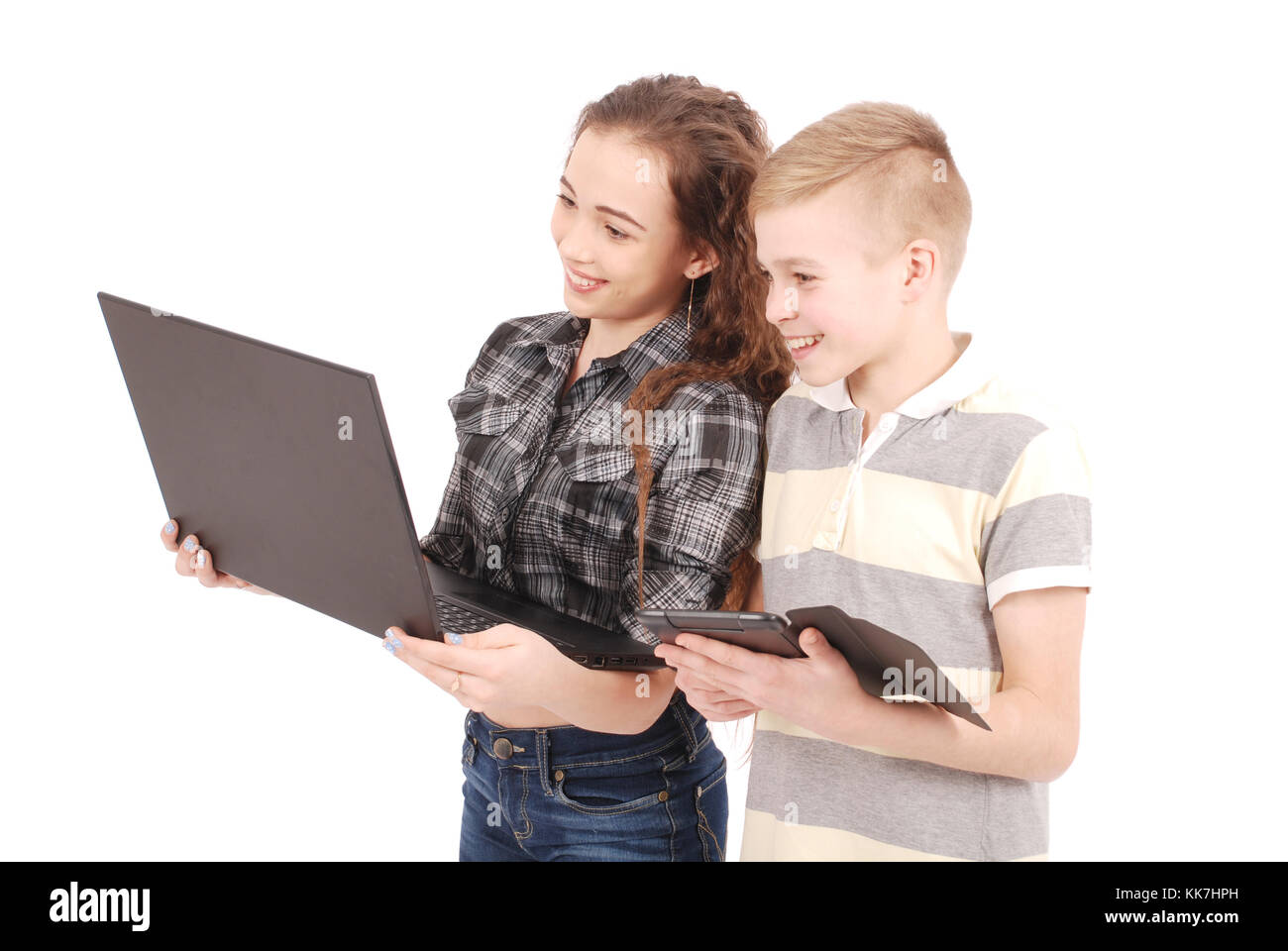 Two kids playing and surfing the web on digital tablet and laptop ...