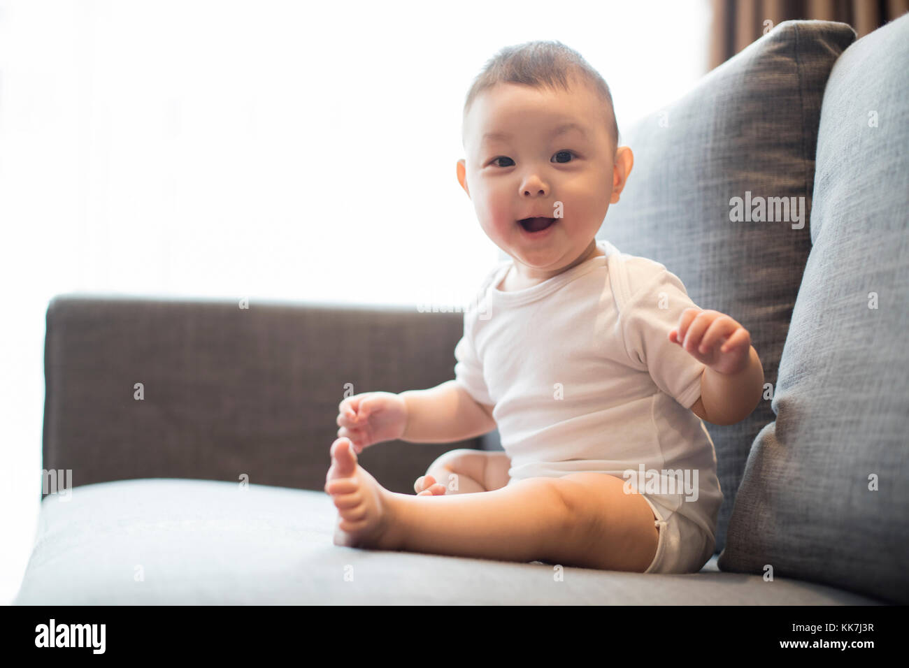 Cute Chinese baby boy sitting on sofa Stock Photo - Alamy