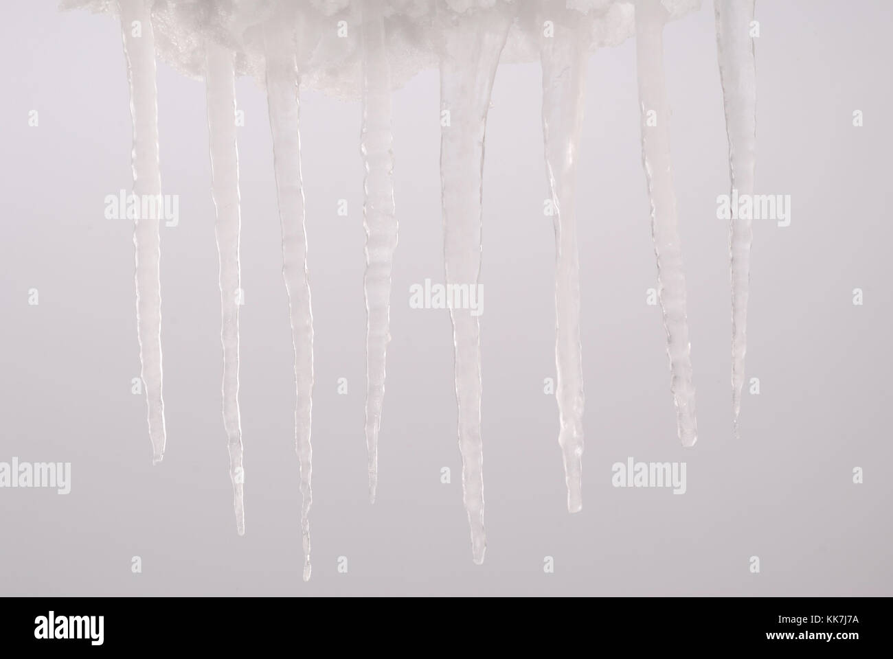 Icicles isolated on a grey background. Frozen water Stock Photo - Alamy