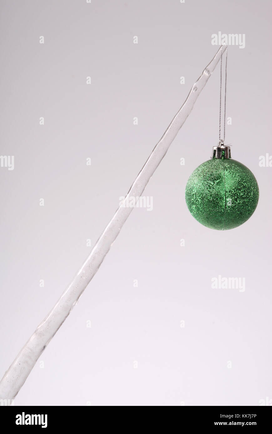 Icicle with a Christmas tree toy isolated on a grey background. Frozen ...