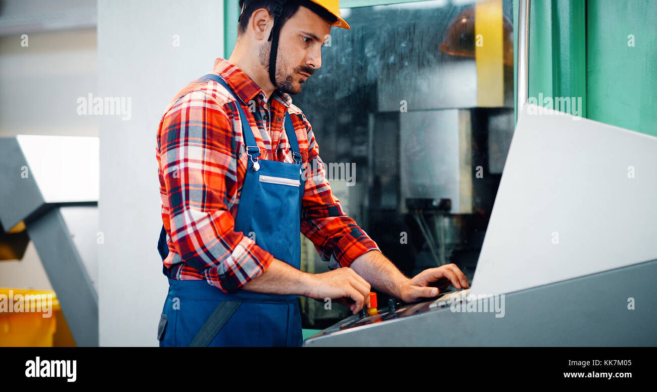Industry Worker entering data in CNC machine at factory Stock Photo - Alamy