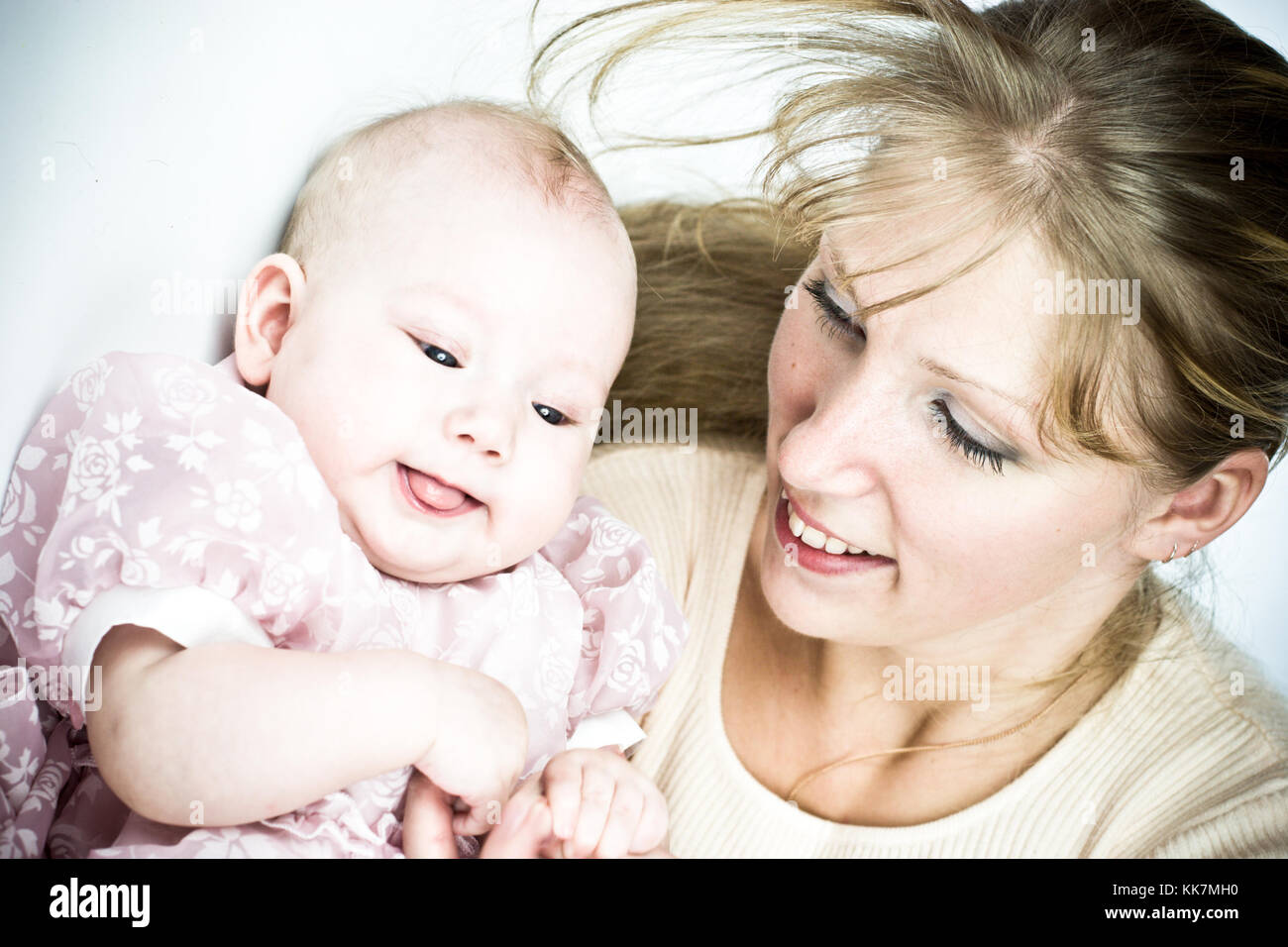 Happy mother holding her baby both smiling Stock Photo - Alamy