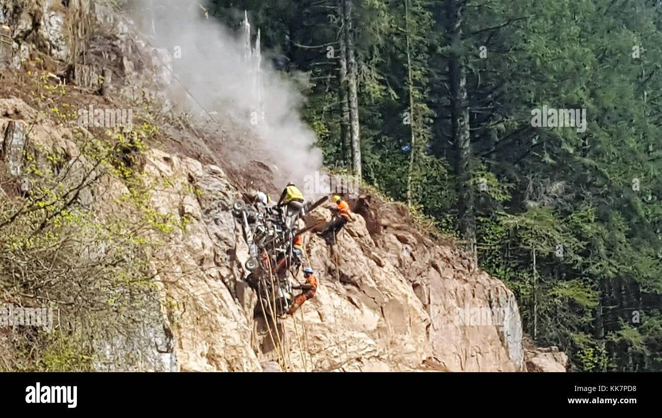 Contractor crews drilling deep in to the hillside installing bolts ...