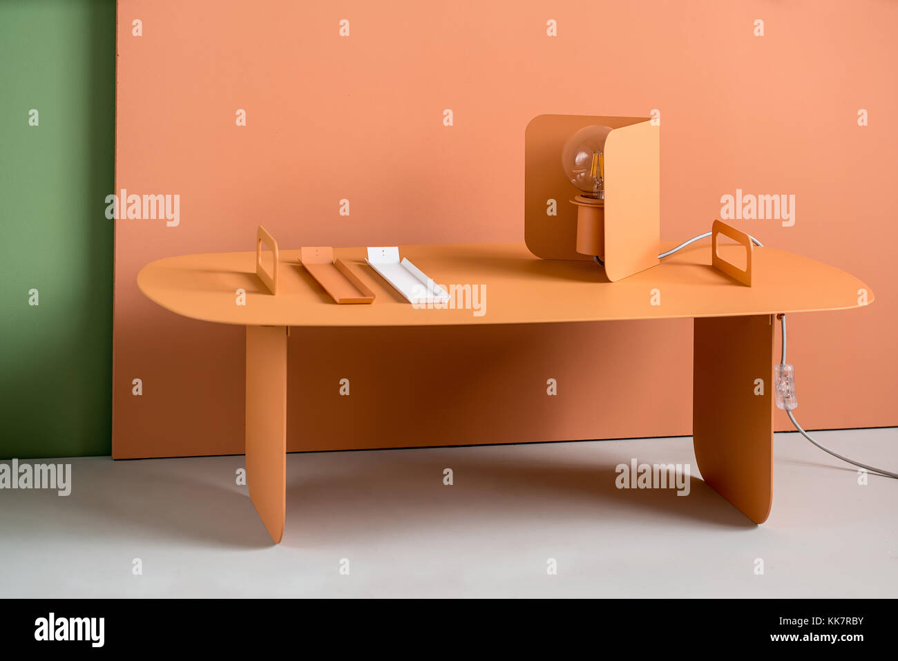Metal orange table with lamp and accessories Stock Photo - Alamy