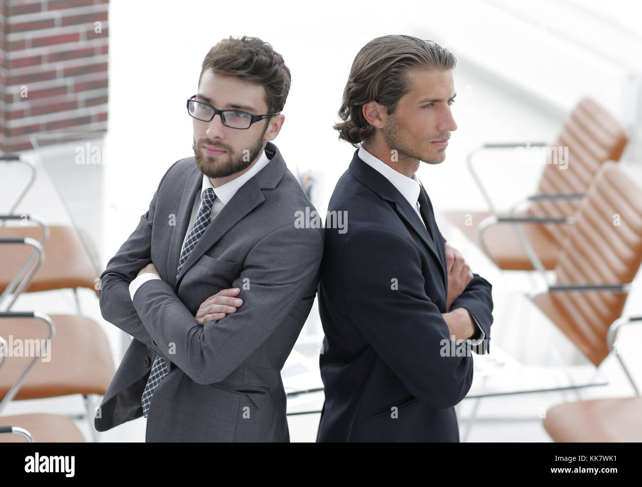Two men standing back to back and support each other Stock Photo - Alamy