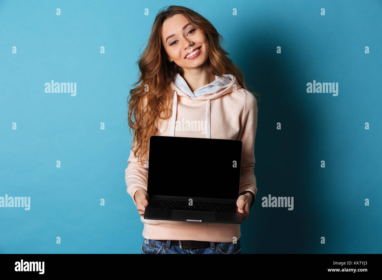 Portrait of a happy friendly girl showing blank screen laptop computer ...