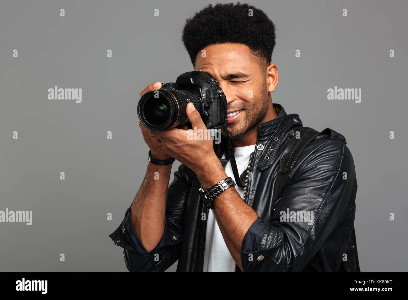 Portrait Of A Smiling Afro American Male Photographer Taking A Photo