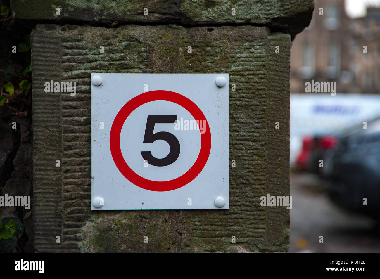 Speed limit sign "5" on a stone wall Stock Photo - Alamy
