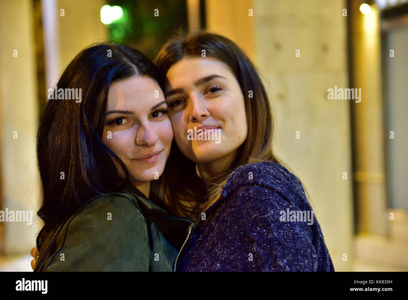 Two female friends hugging on a night out in Athens, Greece Stock Photo ...