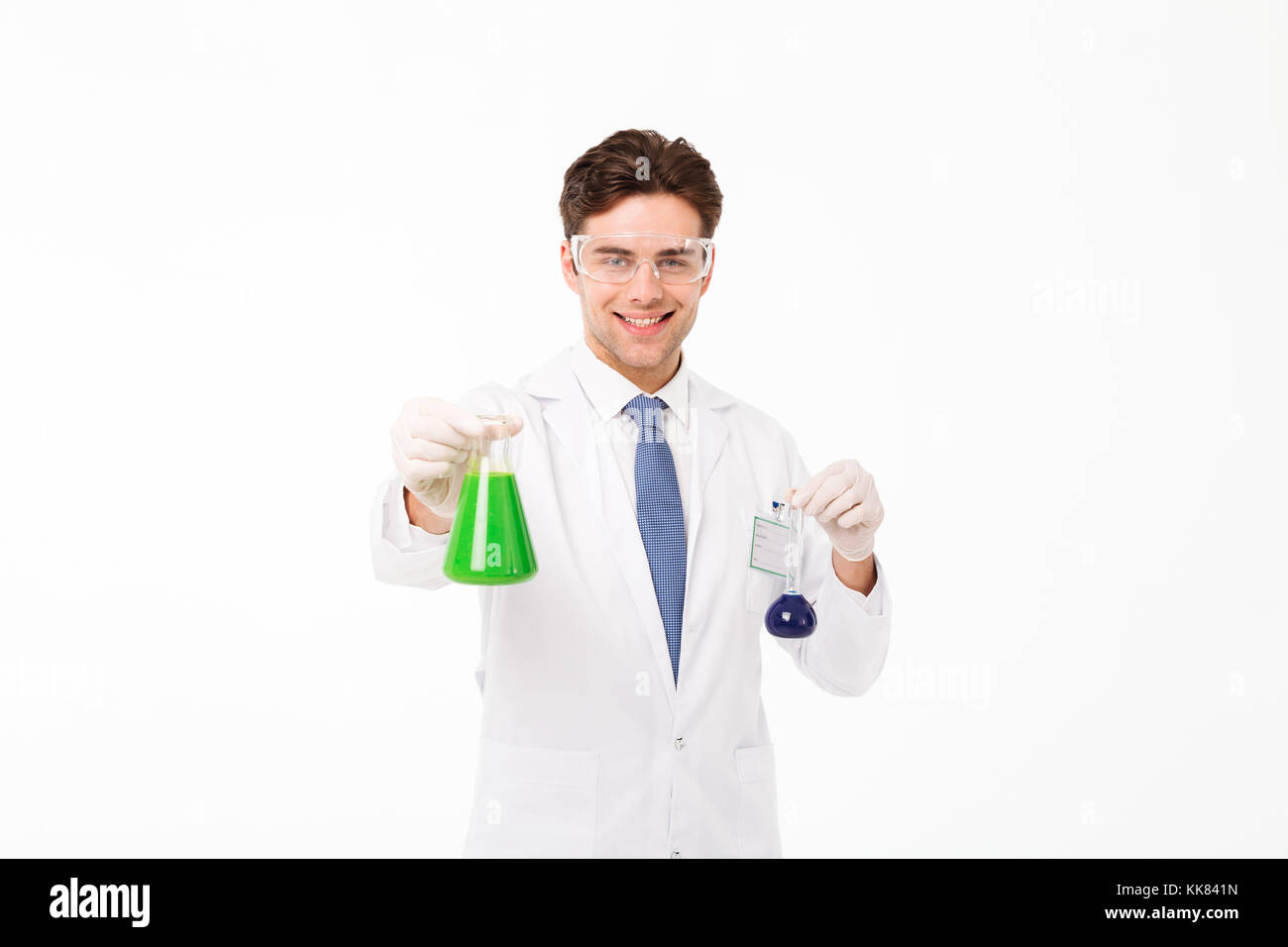 Portrait of a smiling young male scientist dressed in uniform showing ...