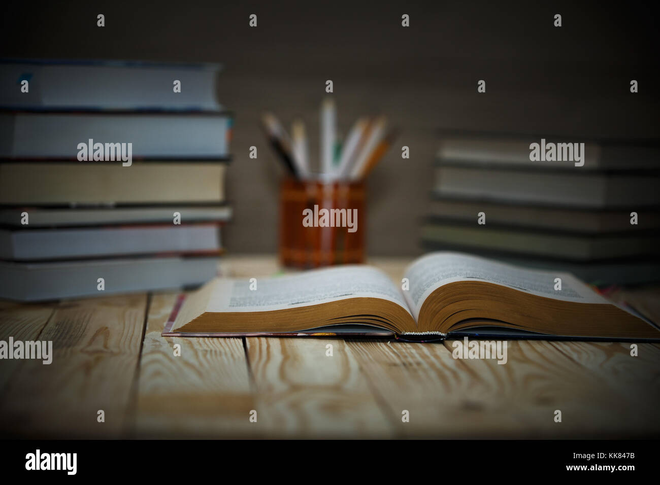 Open textbooks on wood desk with blurred focus for education background ...