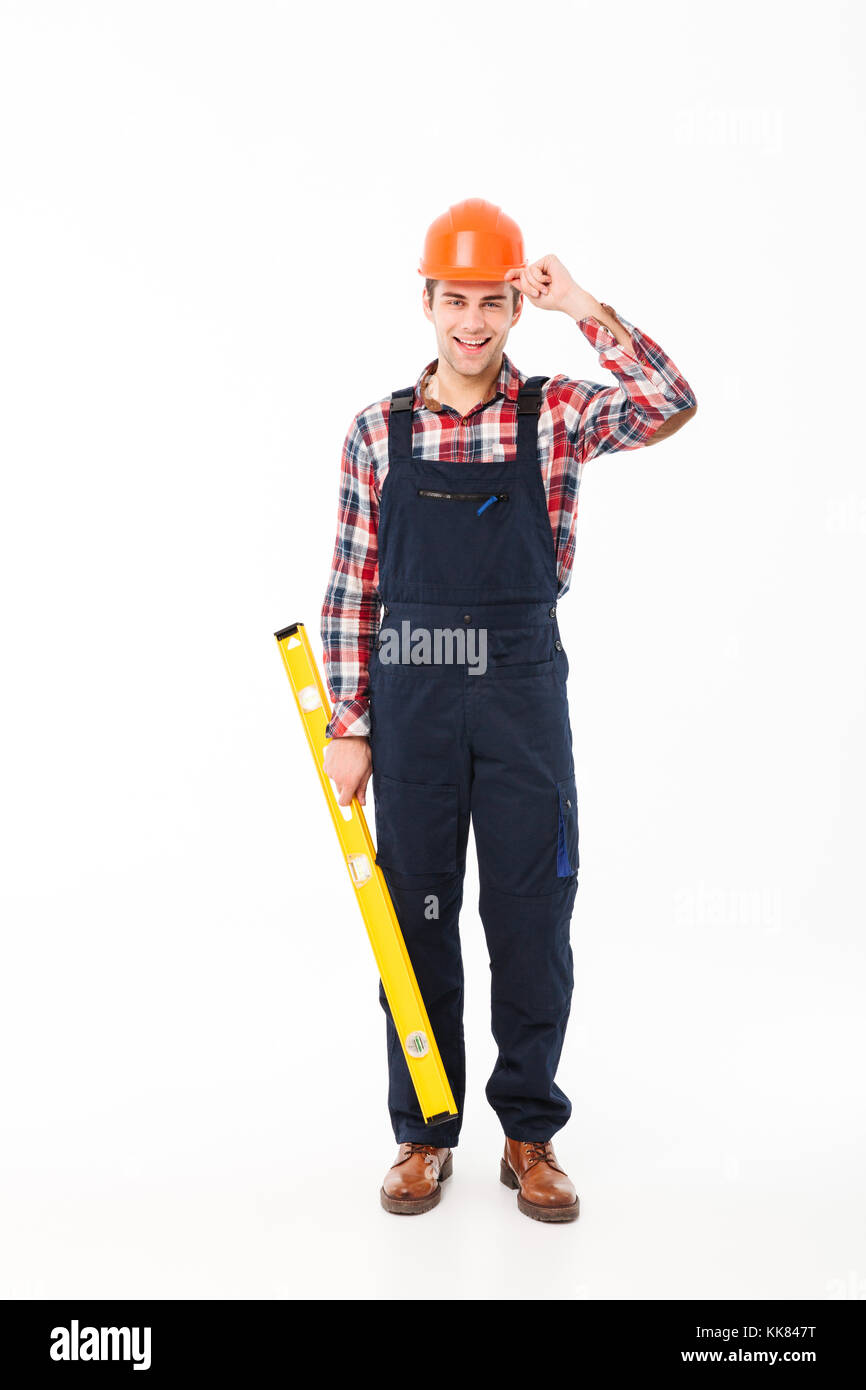 Full length portrait of a handsome young male builder holding spirit ...