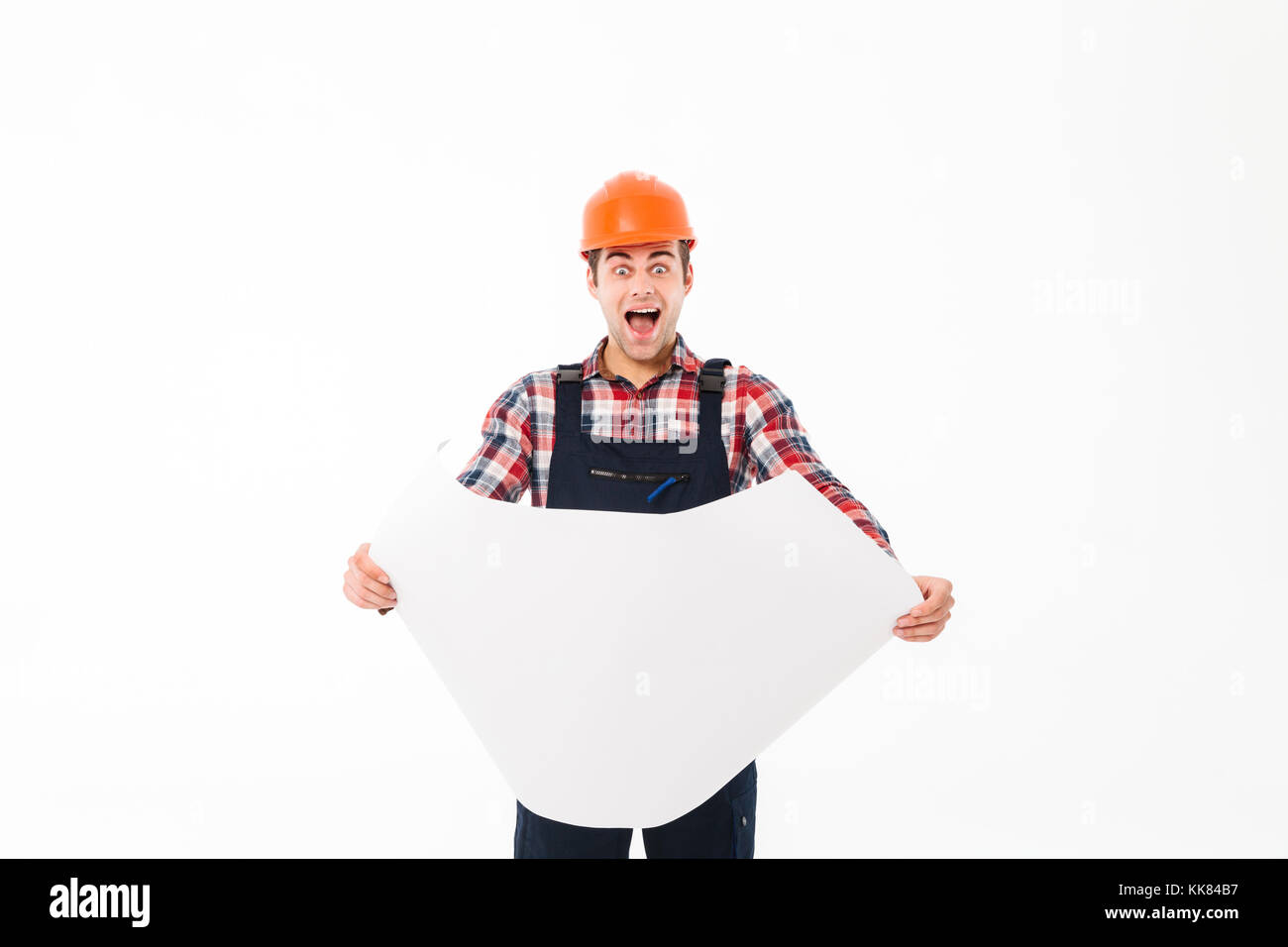 Portrait of a happy excited male builder holding paper draft while ...