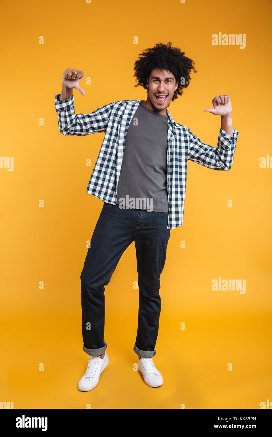 Full length portrait of a happy young african man pointing fingers at ...