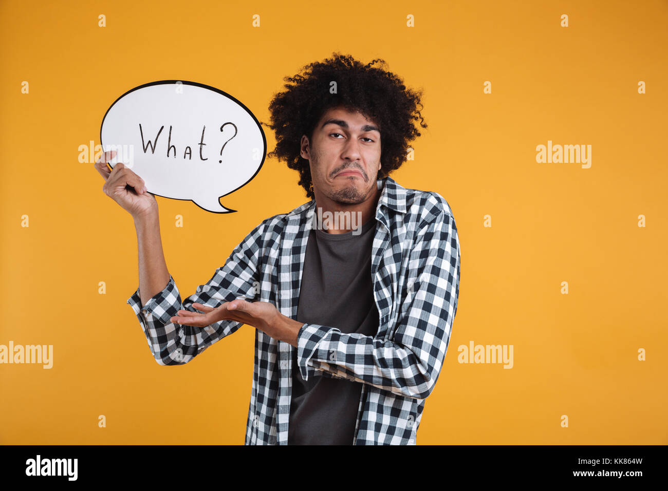 Portrait of a confused doubtful african man holding WHAT speech bubble ...
