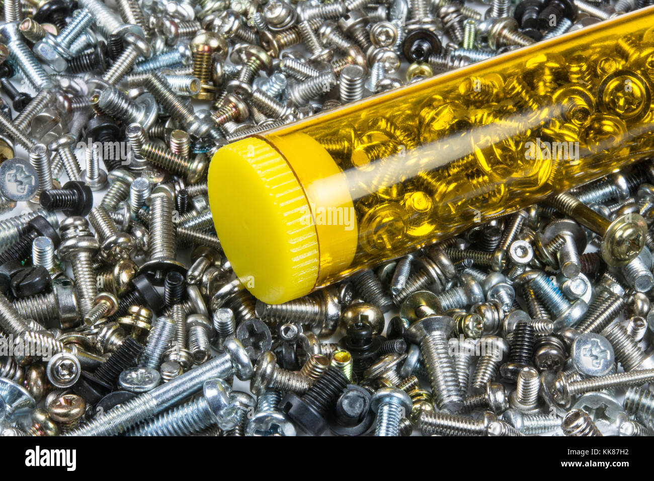 Close-up of metal screws in transparent box. Texture from a pile of ...