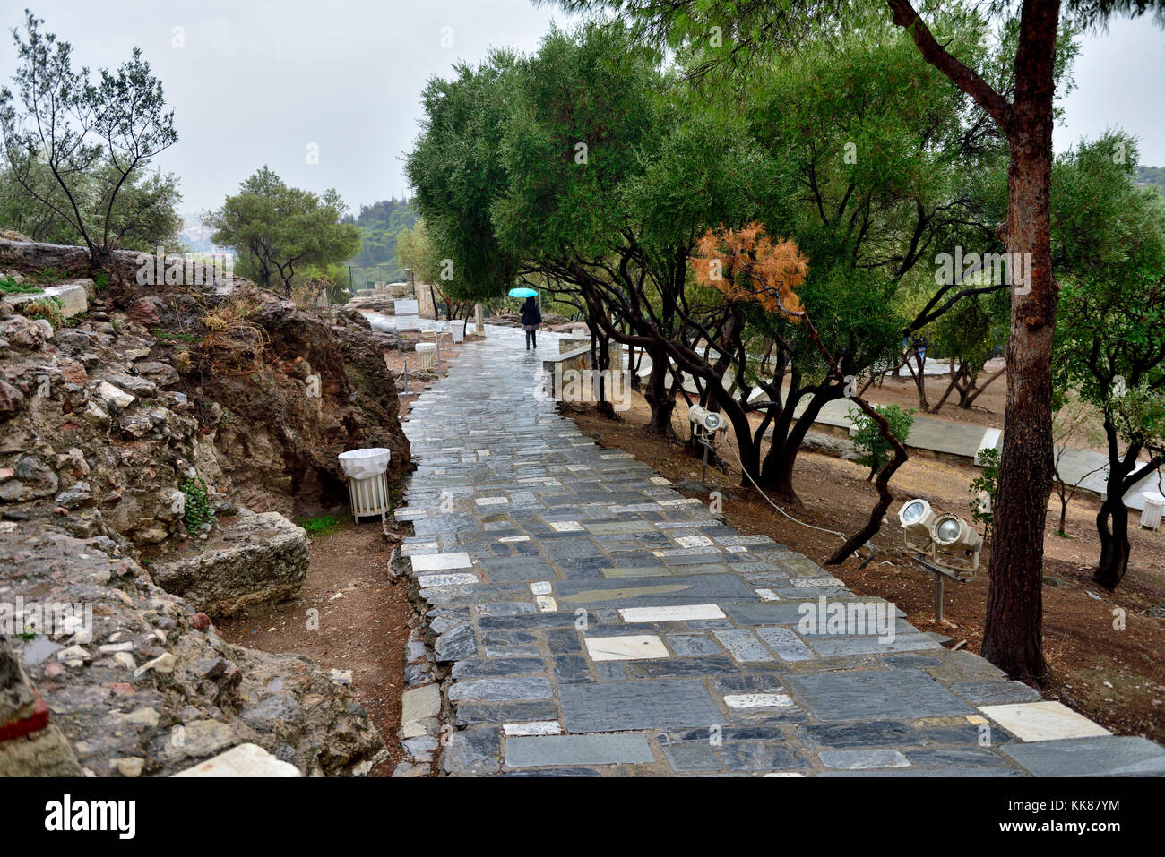 Person with umbrella on curving stone pathway in rain Stock Photo - Alamy