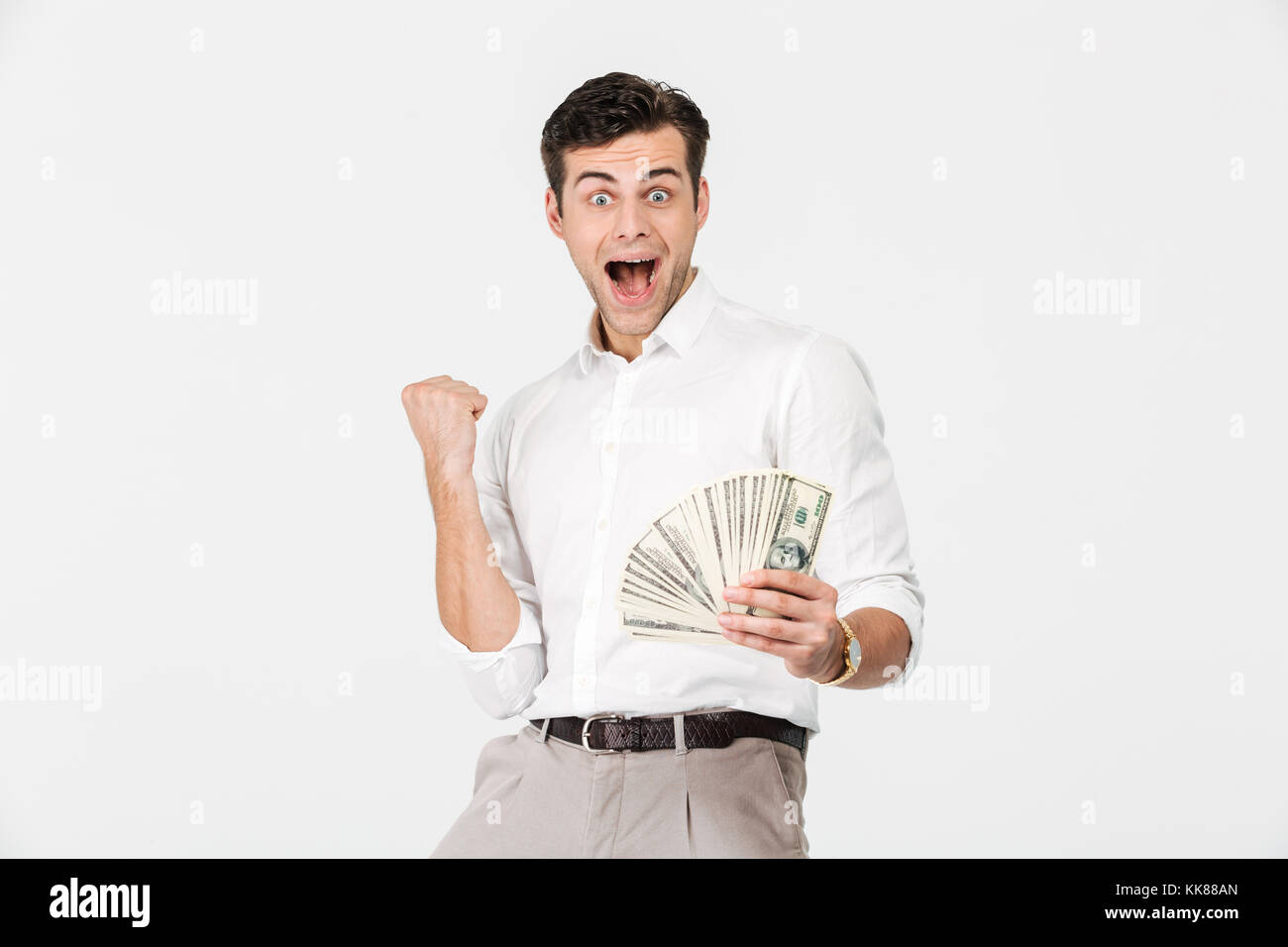 Portrait of a joyful happy man holding bunch of money banknotes and ...
