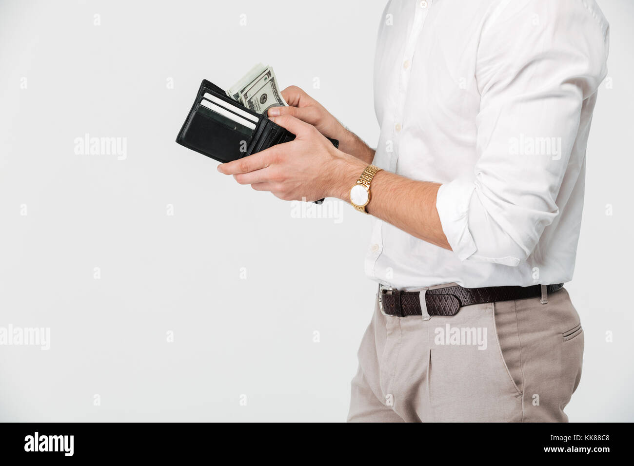 Close up of a man holding wallet full of money isolated over white ...