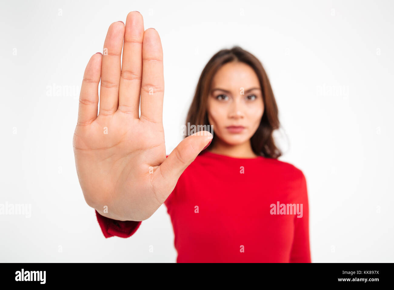 Close up portrait of a serious young asian woman showing stop gesture ...