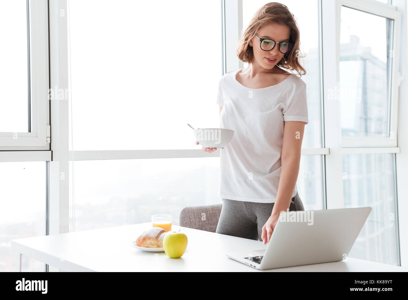 Image of happy young amazing woman standing indoors near table with ...
