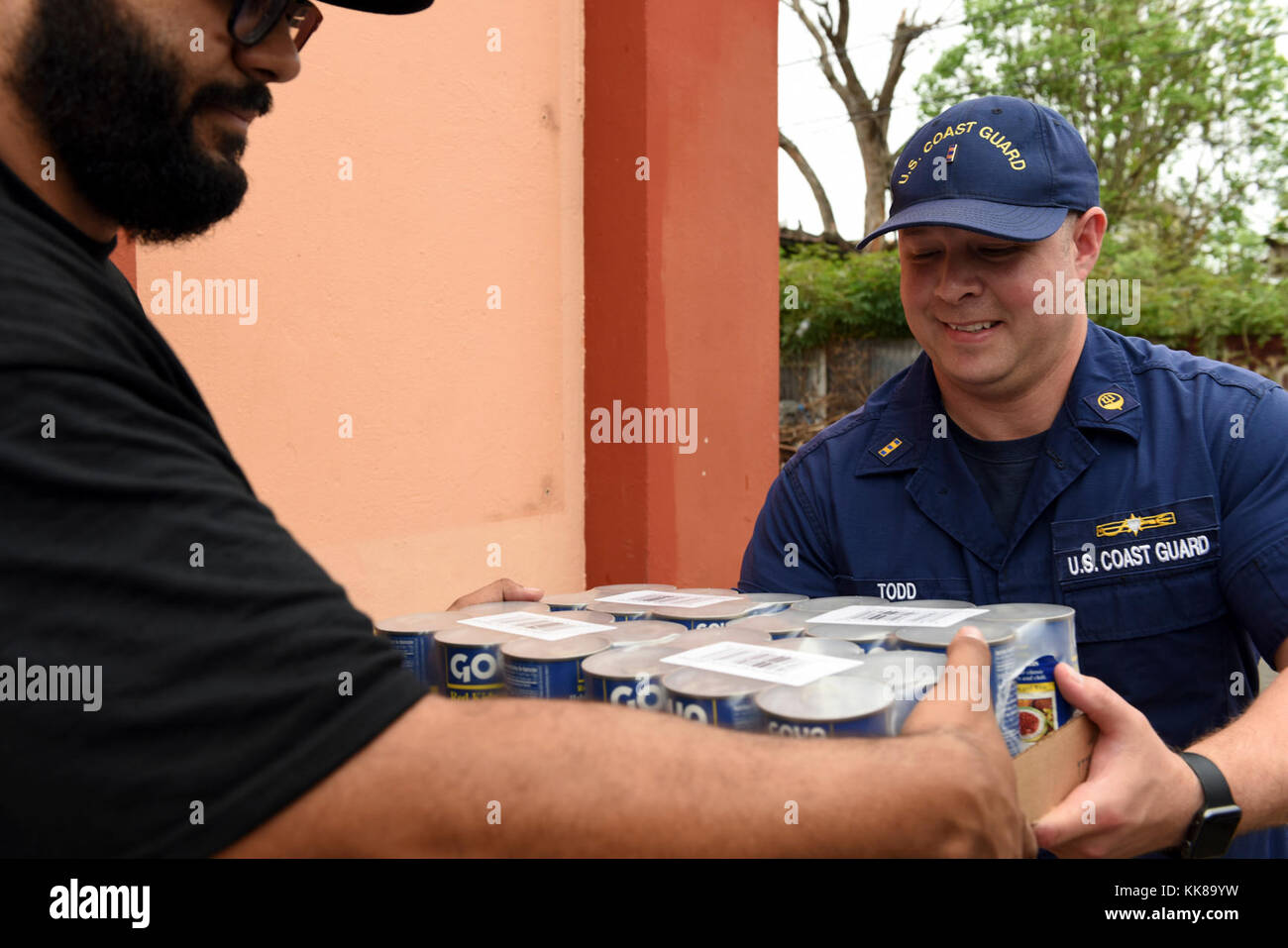 U.S. Coast Guard Chief Warrant Officer Brandon Todd passes supplies to ...