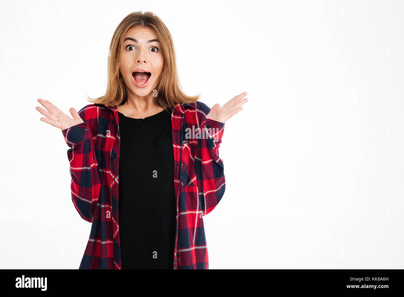 Photo of shocked young woman standing isolated over white wall ...