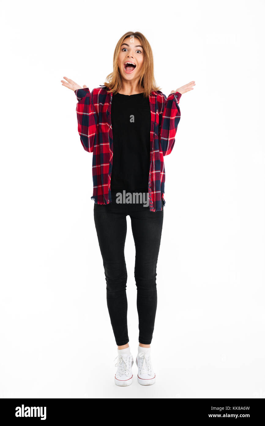 Photo of shocked young woman standing isolated over white wall ...