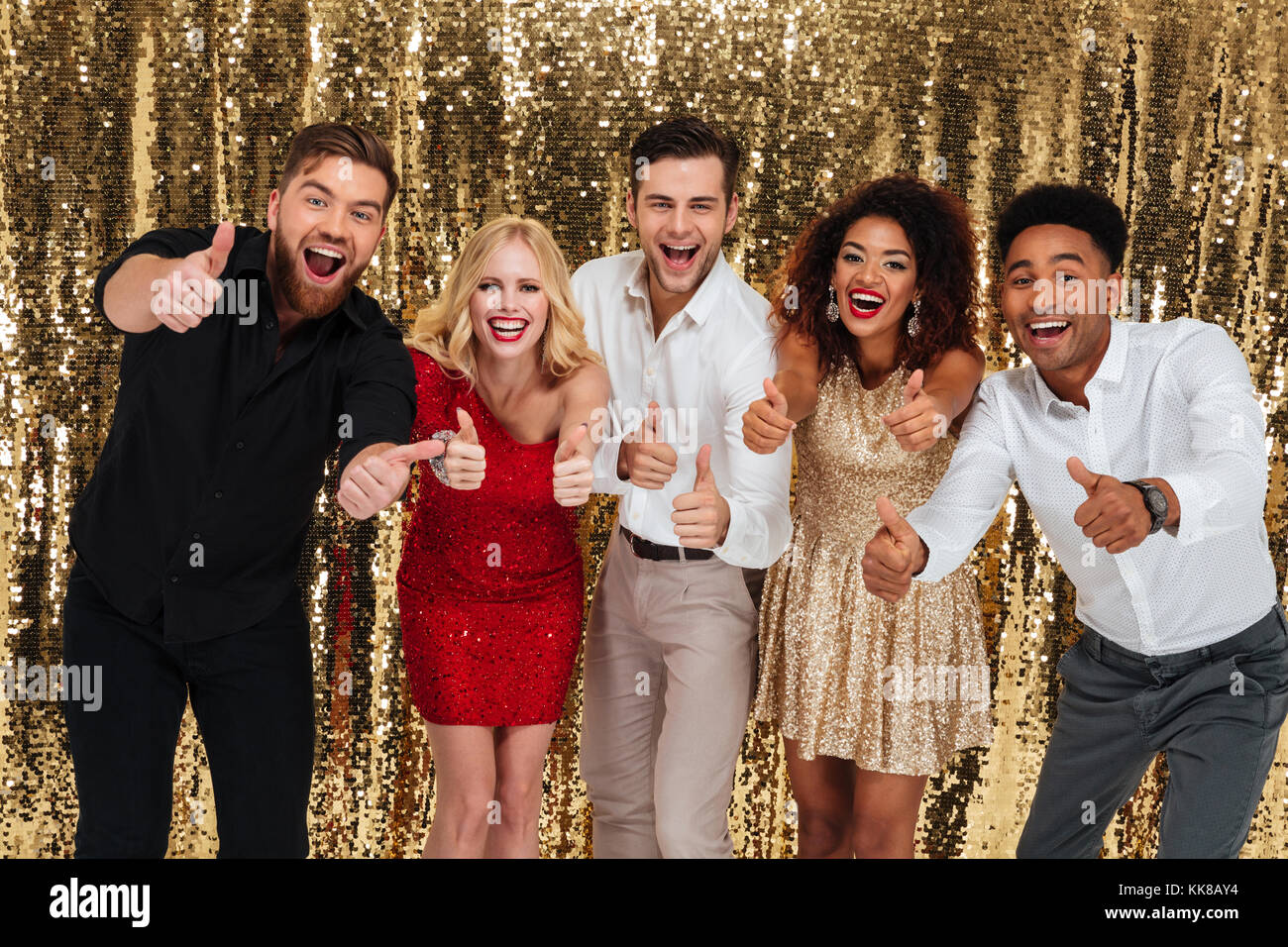 Group of joyful multicultural friends celebrating while standing and ...