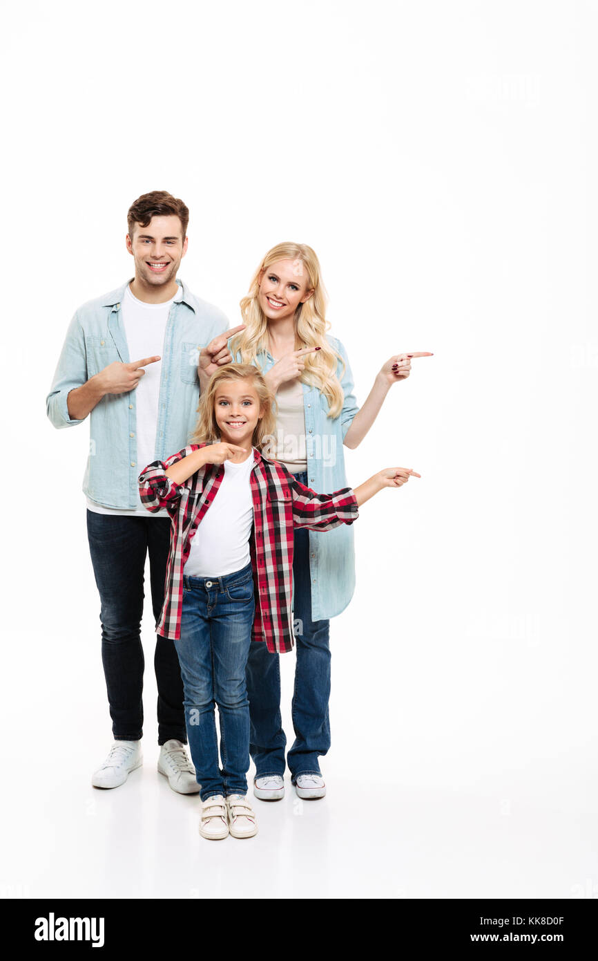 Full length portrait of a cheerful young family with a child standing ...