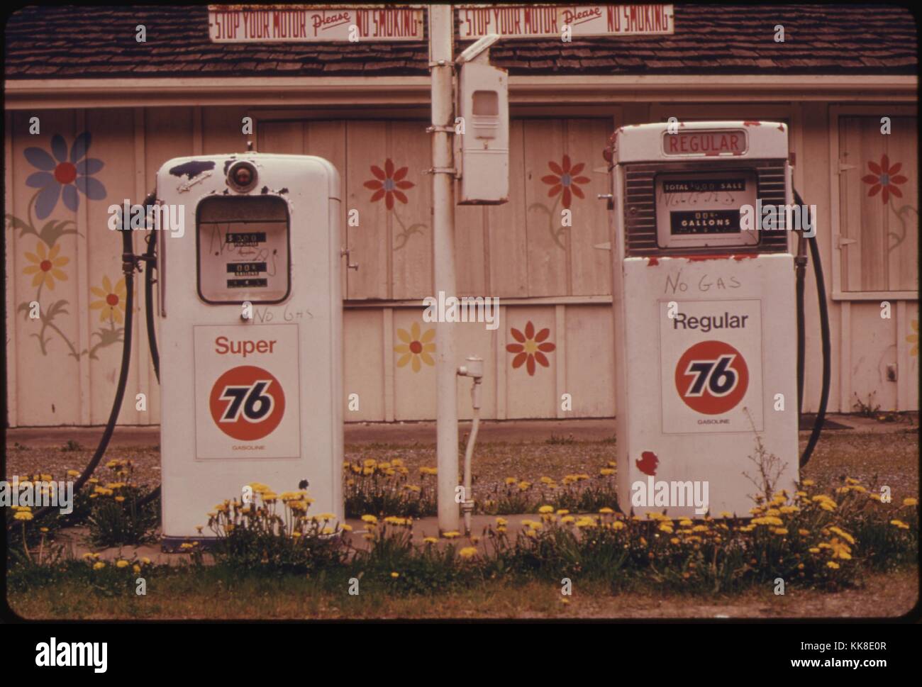 Color photograph of a closed gas station, two pumps can be seen in the ...