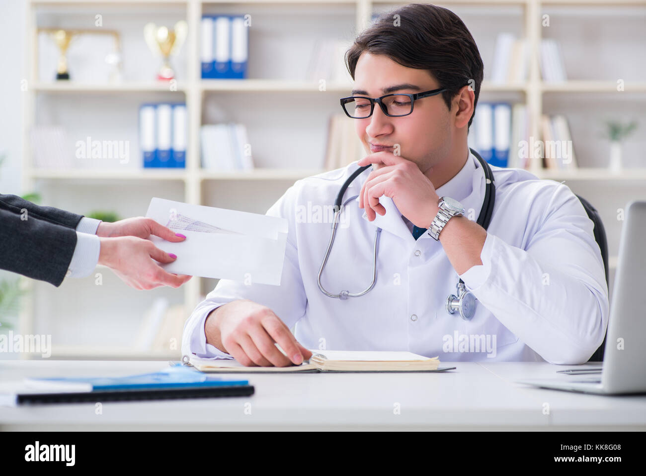 Young doctor in medical insurance fraud concept Stock Photo - Alamy