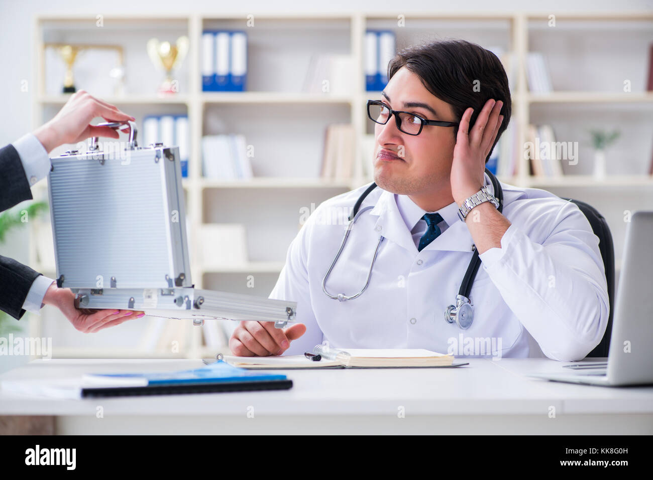 Young doctor in medical insurance fraud concept Stock Photo - Alamy