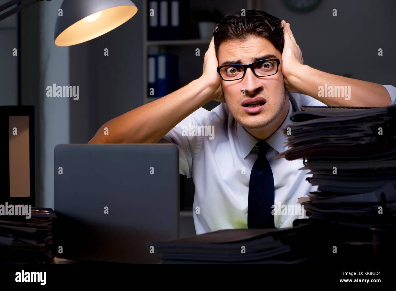 Young businessman working overtime late in office Stock Photo - Alamy