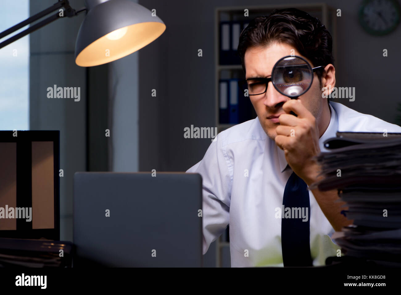 Young businessman working overtime late in office Stock Photo - Alamy