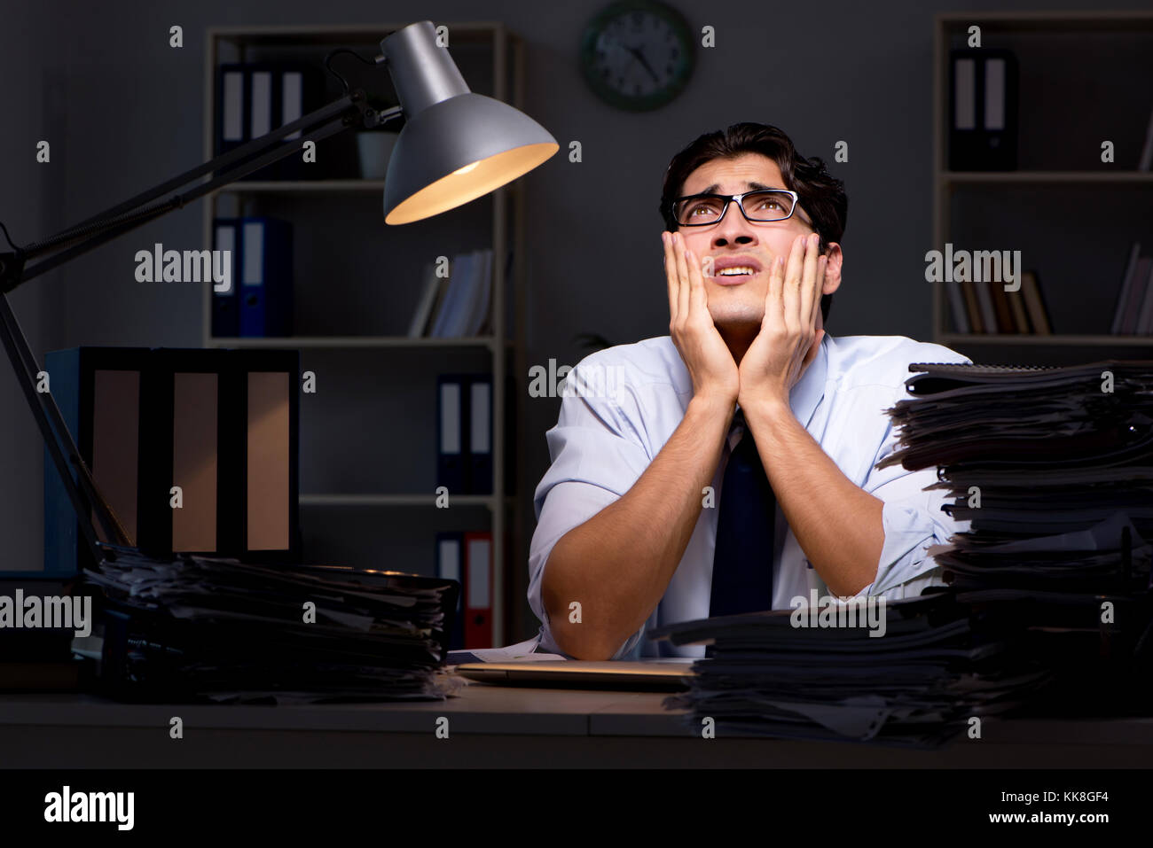 Young businessman working overtime late in office Stock Photo - Alamy