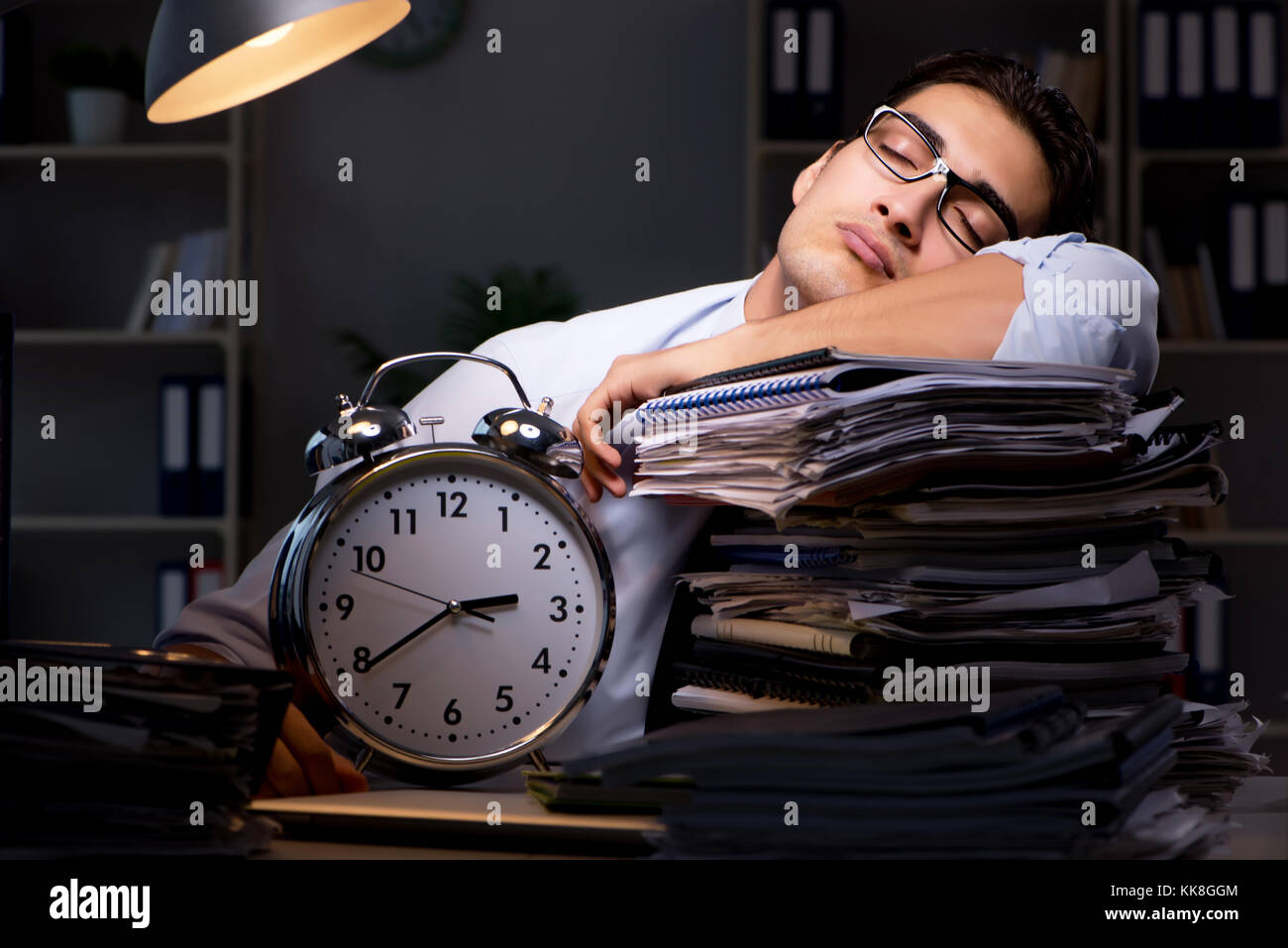 Young businessman working overtime late in office Stock Photo - Alamy