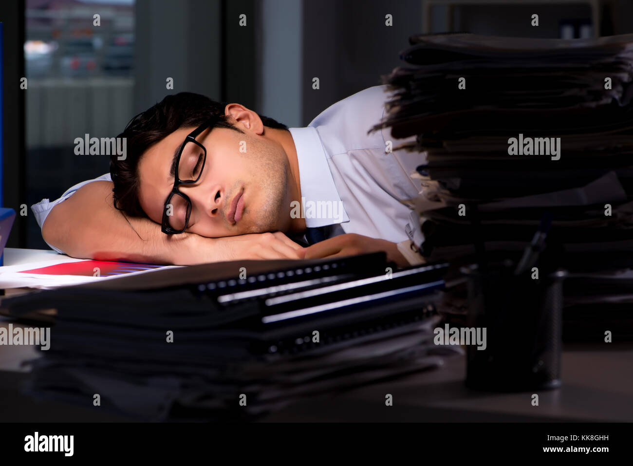 Young businessman working overtime late in office Stock Photo - Alamy