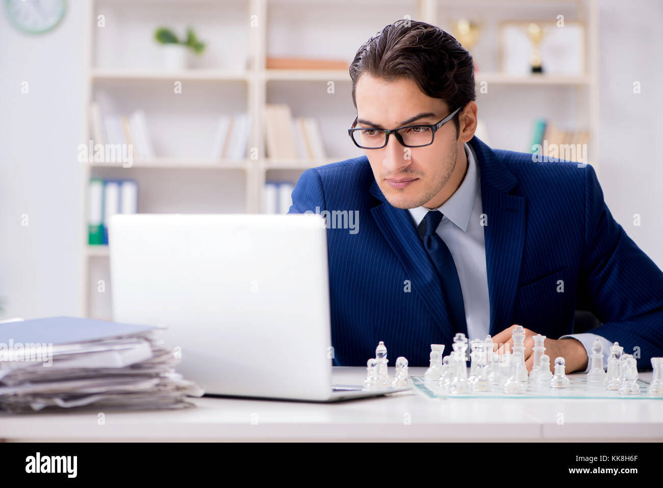 Young businessman playing glass chess in office Stock Photo - Alamy