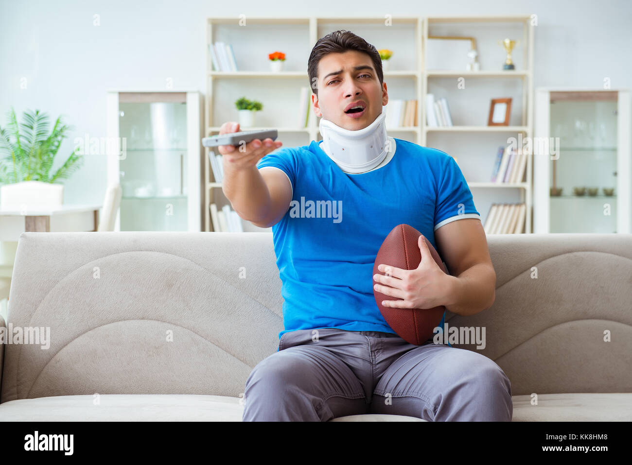 Man with neck injury watching american football at home Stock Photo - Alamy