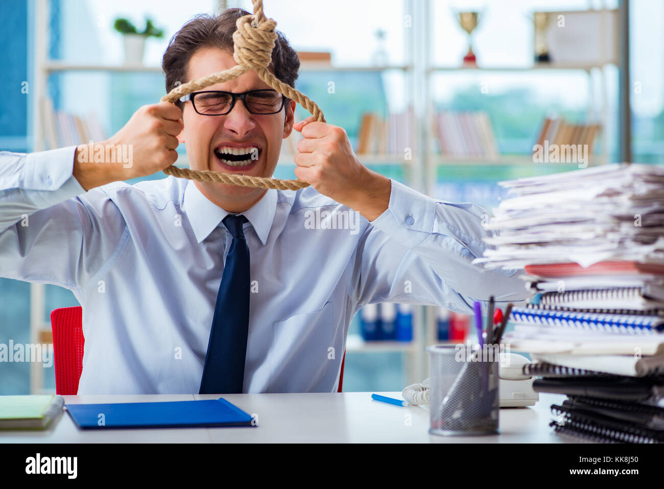 Unhappy businessman thinking of hanging himself in the office Stock ...