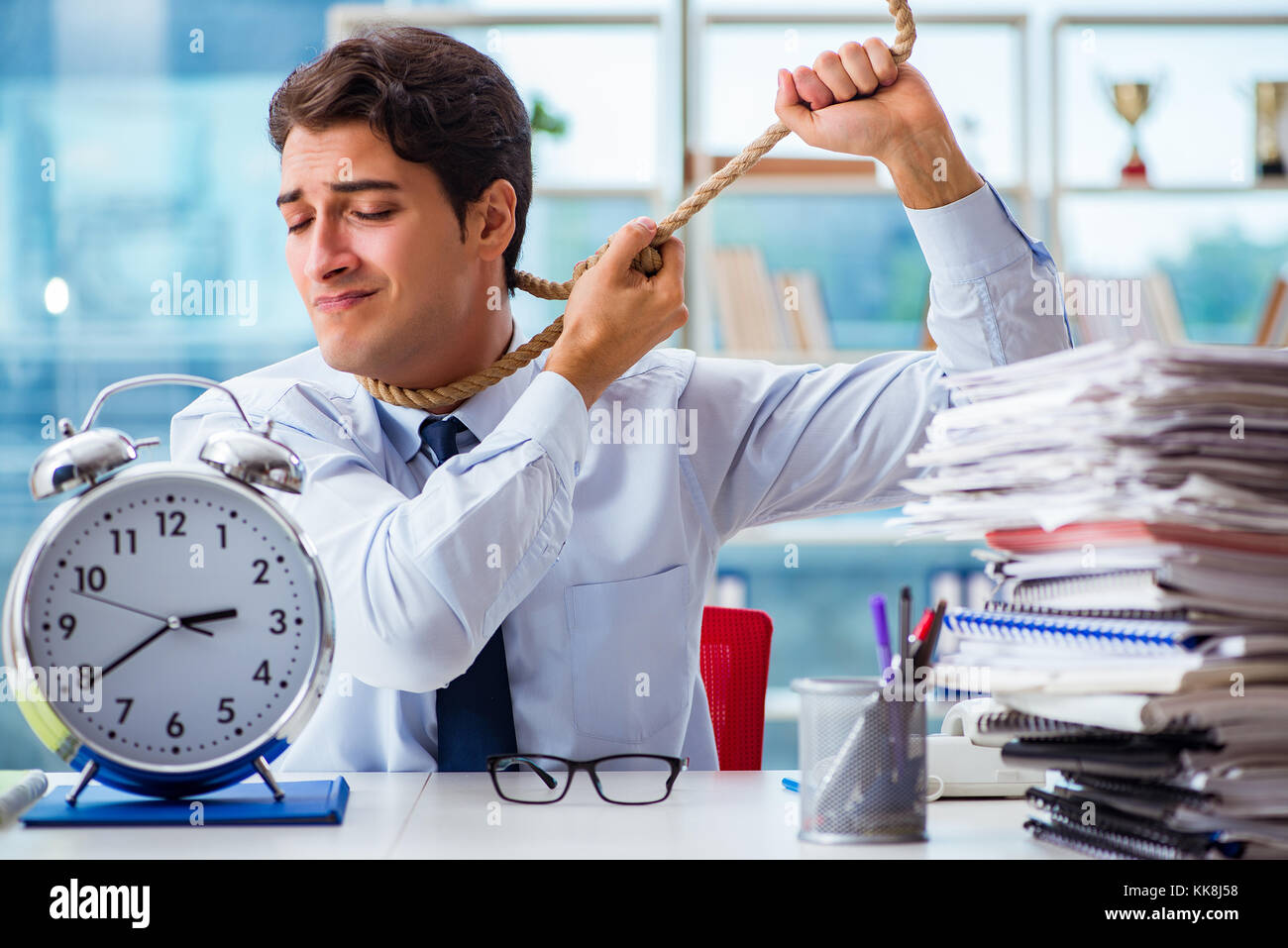 Unhappy businessman thinking of hanging himself in the office Stock ...