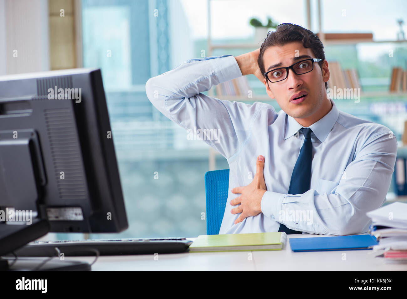 Businessman suffering from excessive armpit sweating Stock Photo - Alamy