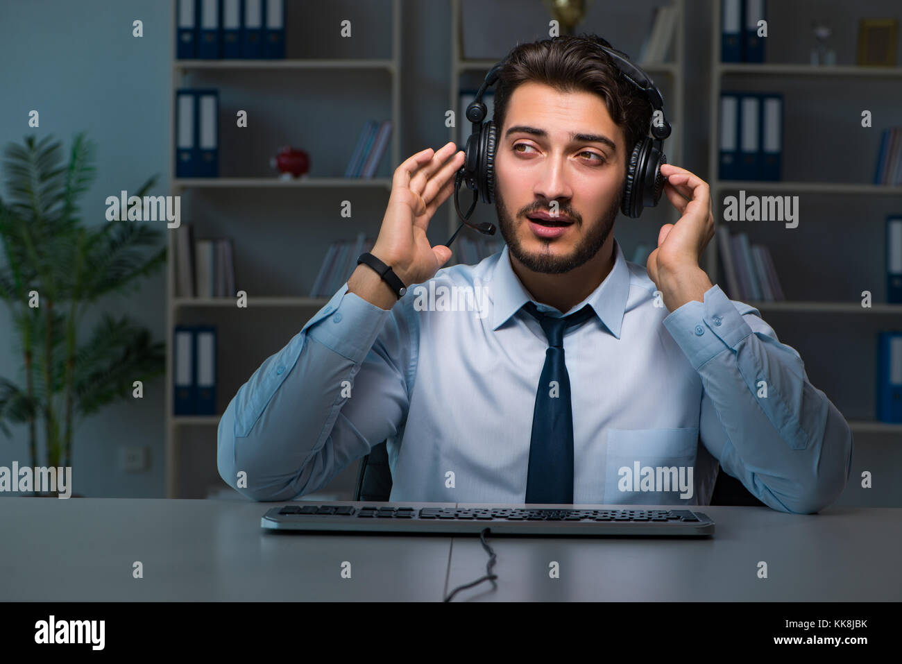 Young man in call center concept working late overtime in office Stock ...
