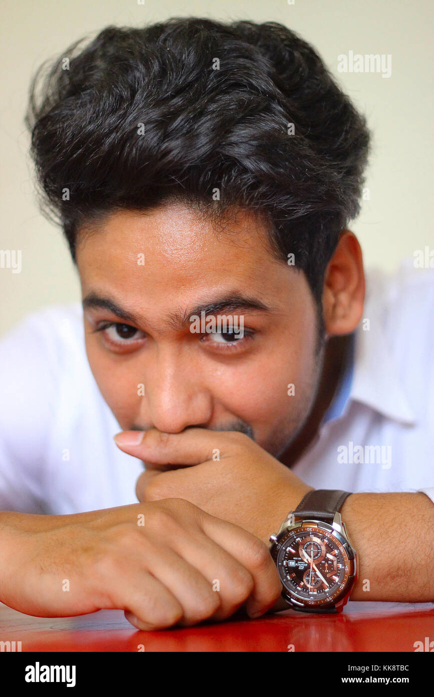 Young man, covering his mouth with his hands playfully Stock Photo - Alamy