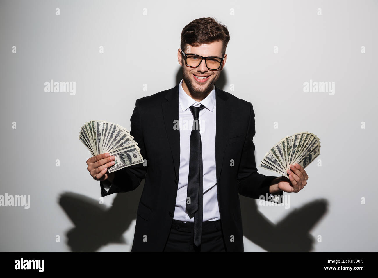 Close-up portrait of handsome smiling man in glasses holding bunches of ...