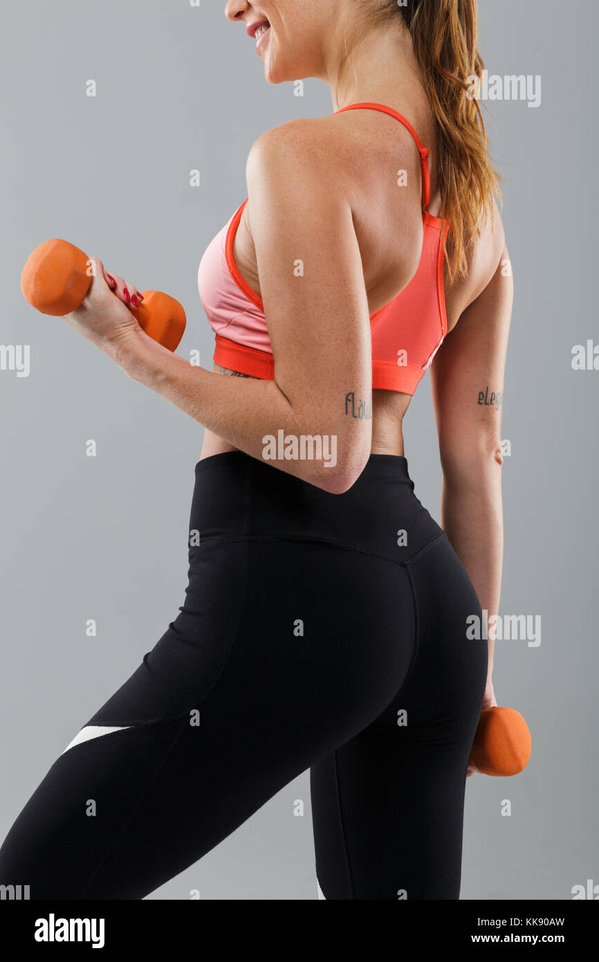Cropped side view image of a young sports woman doing exercise with ...