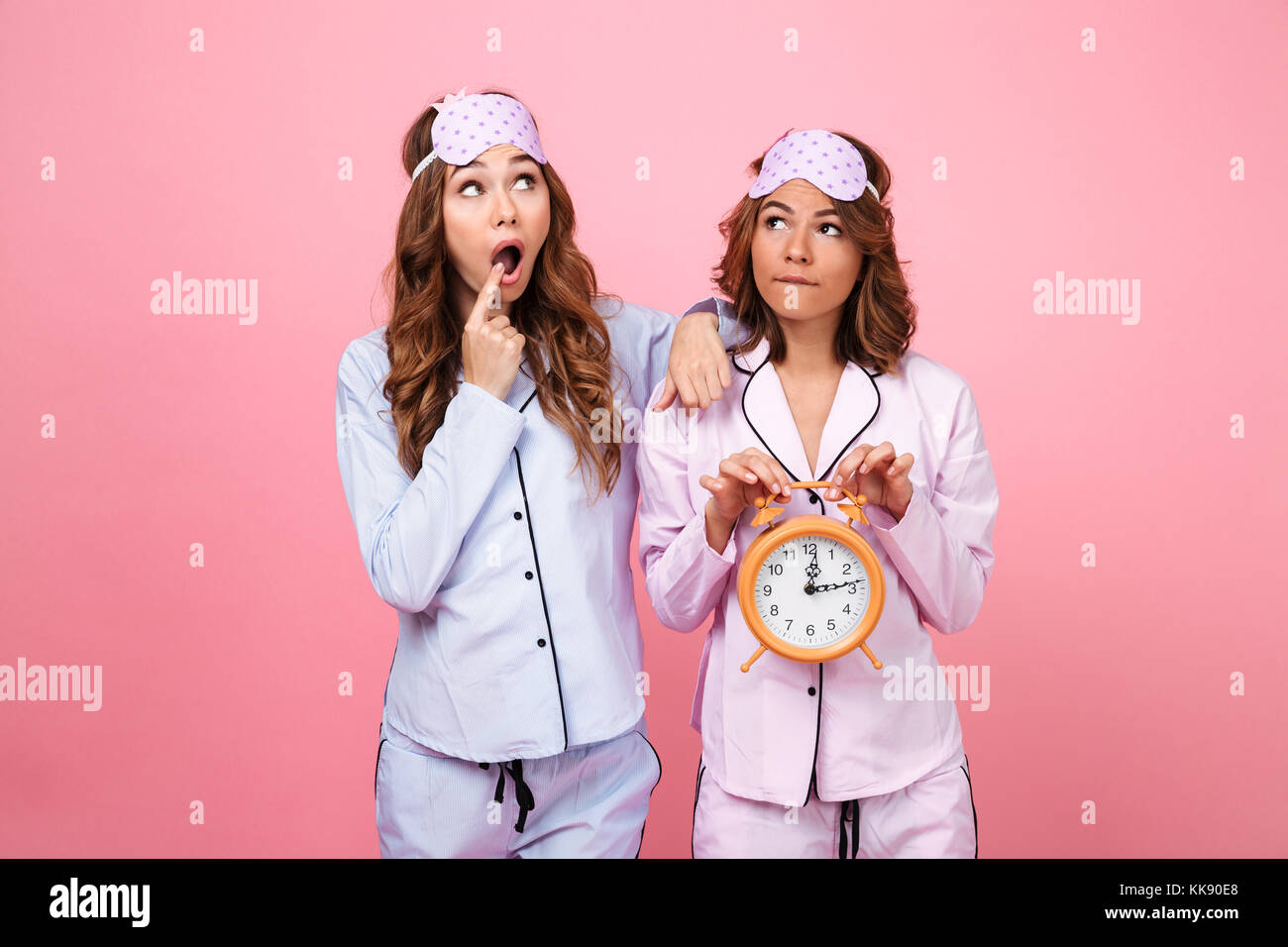 Image of two shocked friends women in pajamas isolated over pink ...
