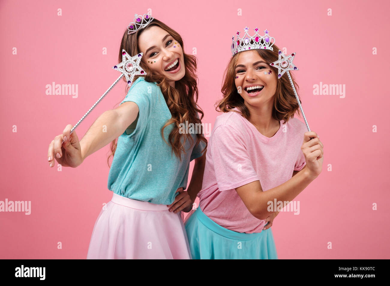 Portrait of happy excited girls dressed in princess costumes holding ...
