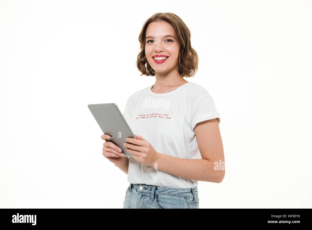Portrait of a happy smiling girl holding tablet computer and looking at ...